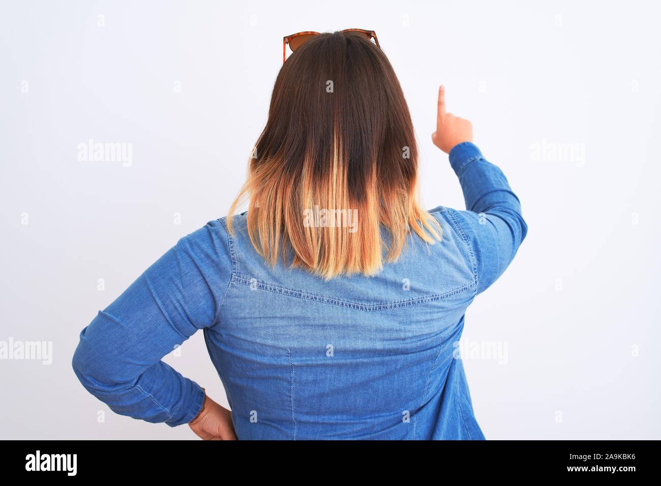 Beautiful woman wearing denim shirt standing over isolated white ...