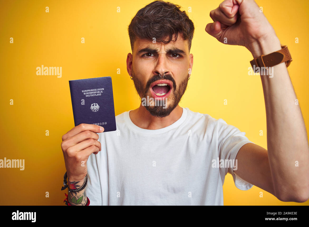 Young man with tattoo wearing German Germany passport over isolated ...