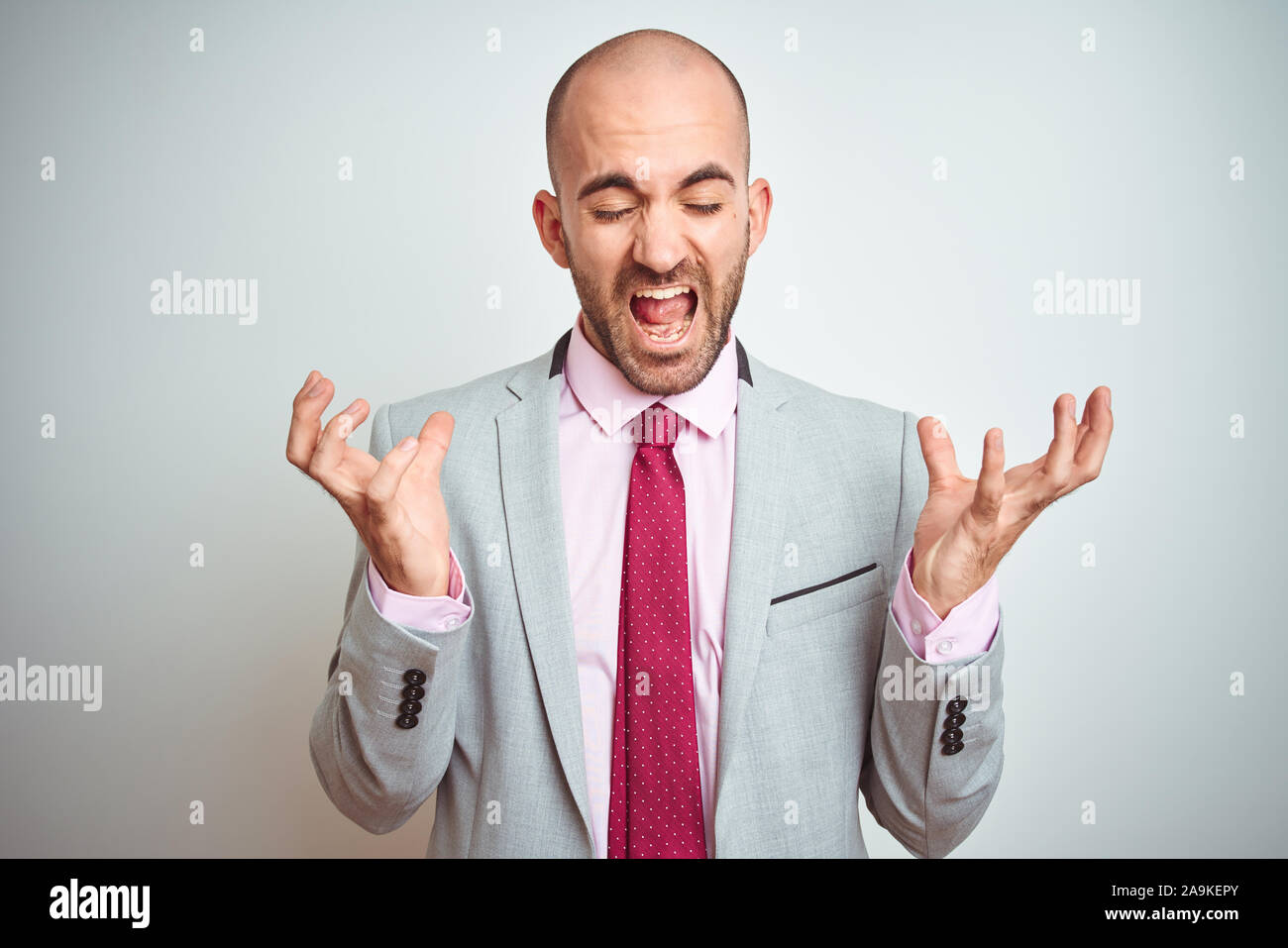 Young business man wearing suit and purple tie over isolated background ...