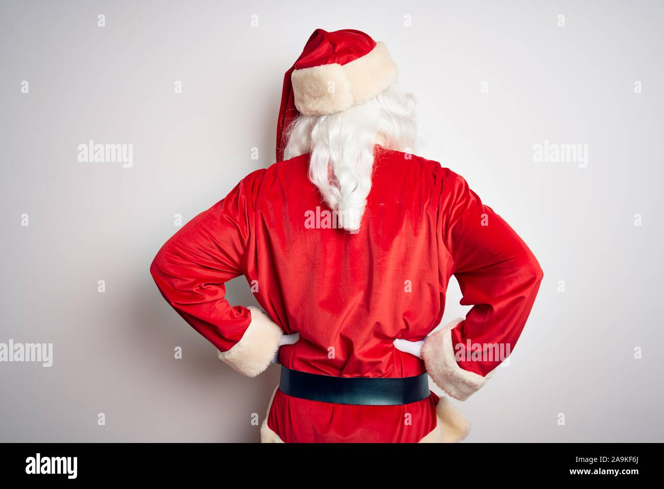 Middle age handsome man wearing Santa costume standing over isolated ...