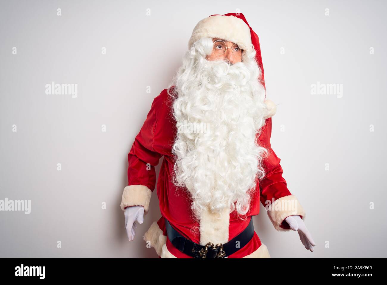 Middle age handsome man wearing Santa costume standing over isolated ...