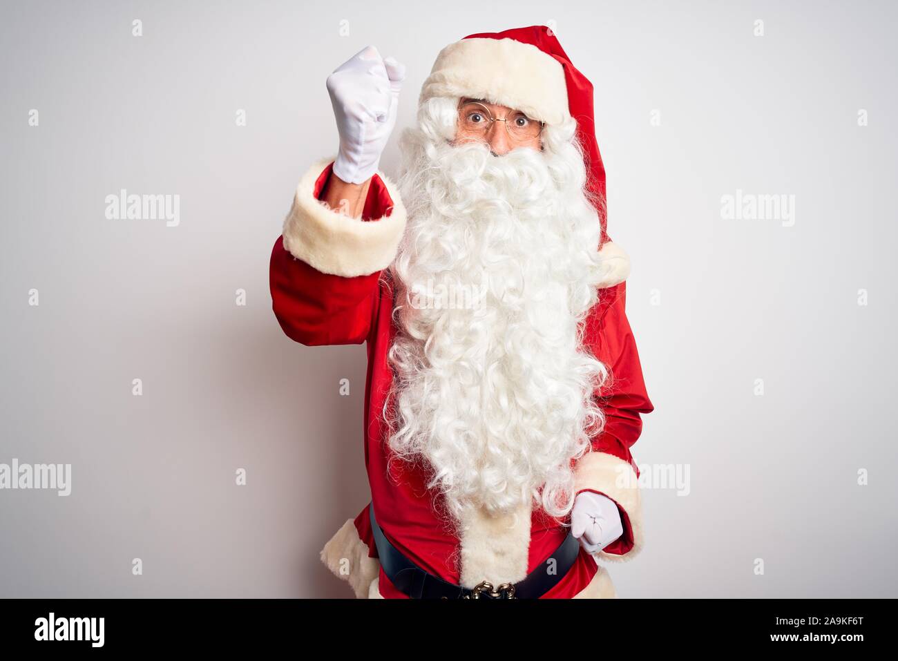 Middle age handsome man wearing Santa costume standing over isolated ...