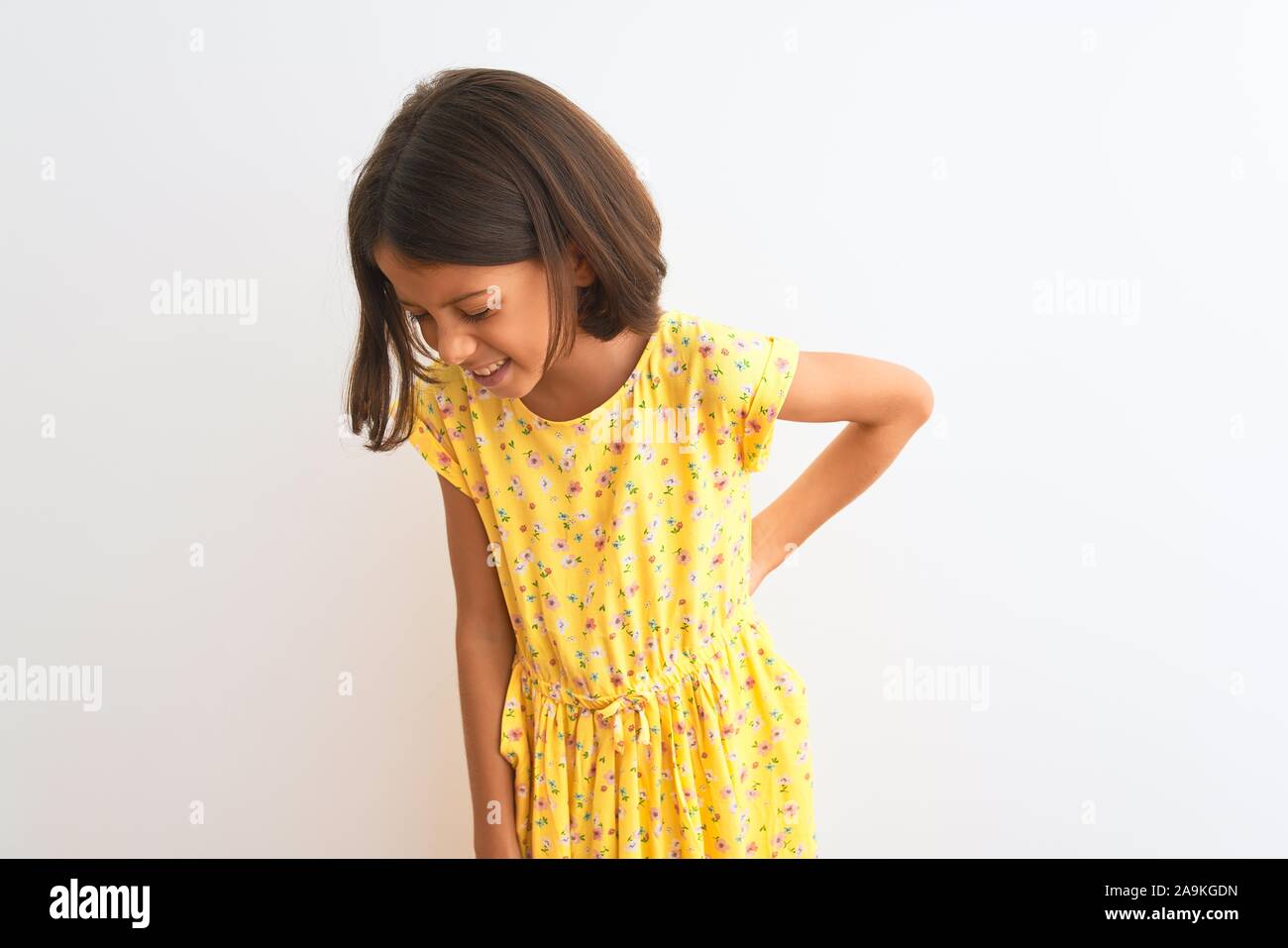 Young beautiful child girl wearing yellow floral dress standing over ...