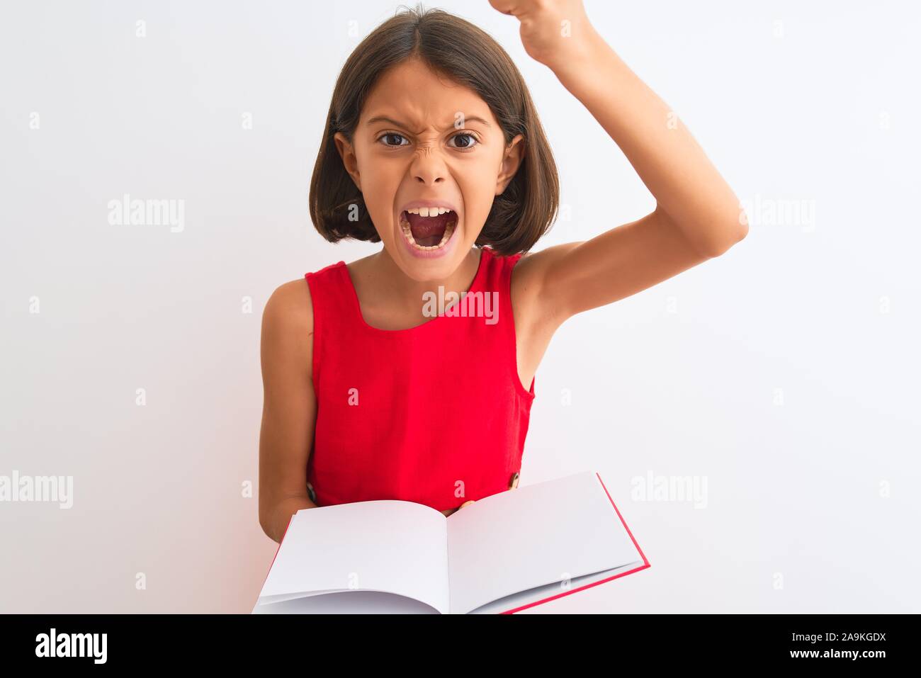 Beautiful student child girl reading red book standing over isolated ...