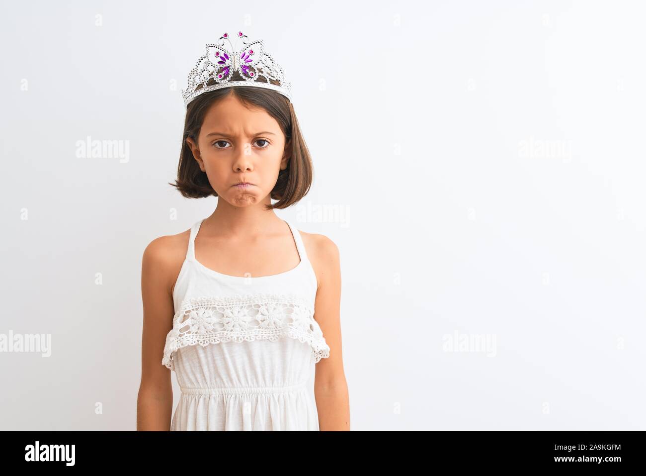 Beautiful child girl wearing princess crown standing over isolated ...