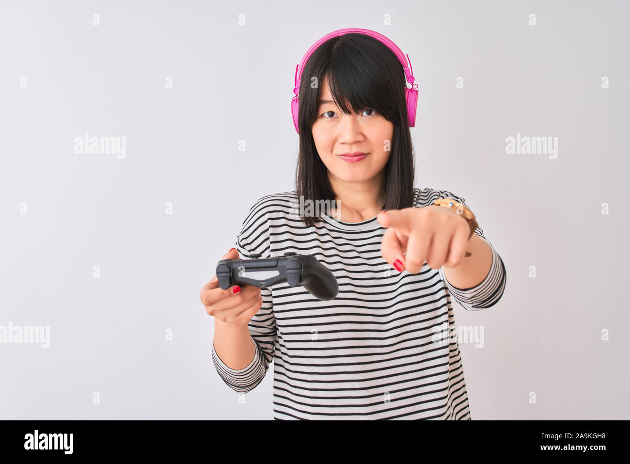Chinese gamer woman playing video game using headphones over isolated ...