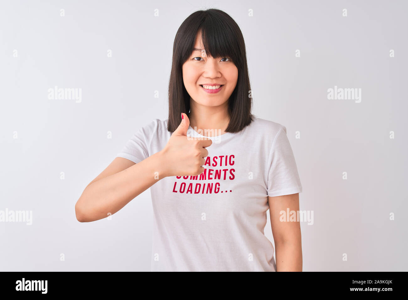 Young beautiful Chinese woman wearing fanny t-shirt over isolated white ...