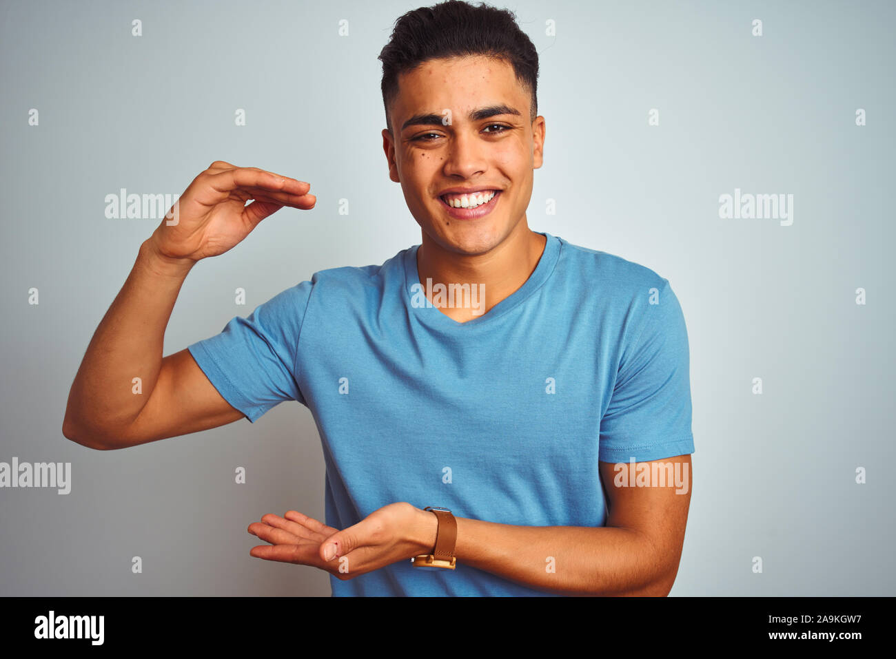 Young brazilian man wearing blue t-shirt standing over isolated white ...