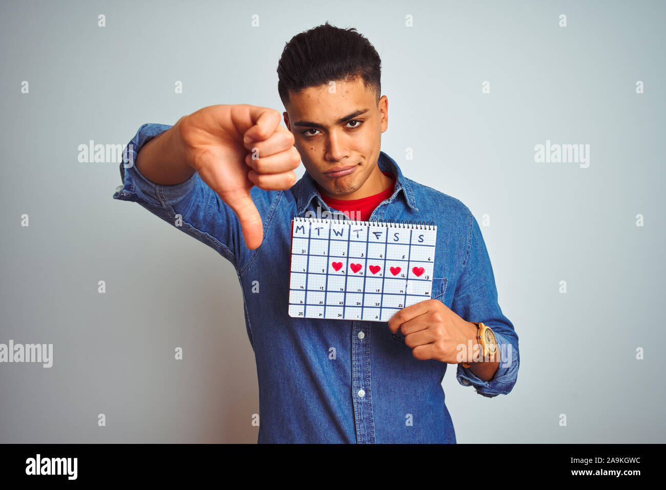 Young brazilian man holding calendar standing over isolated white ...