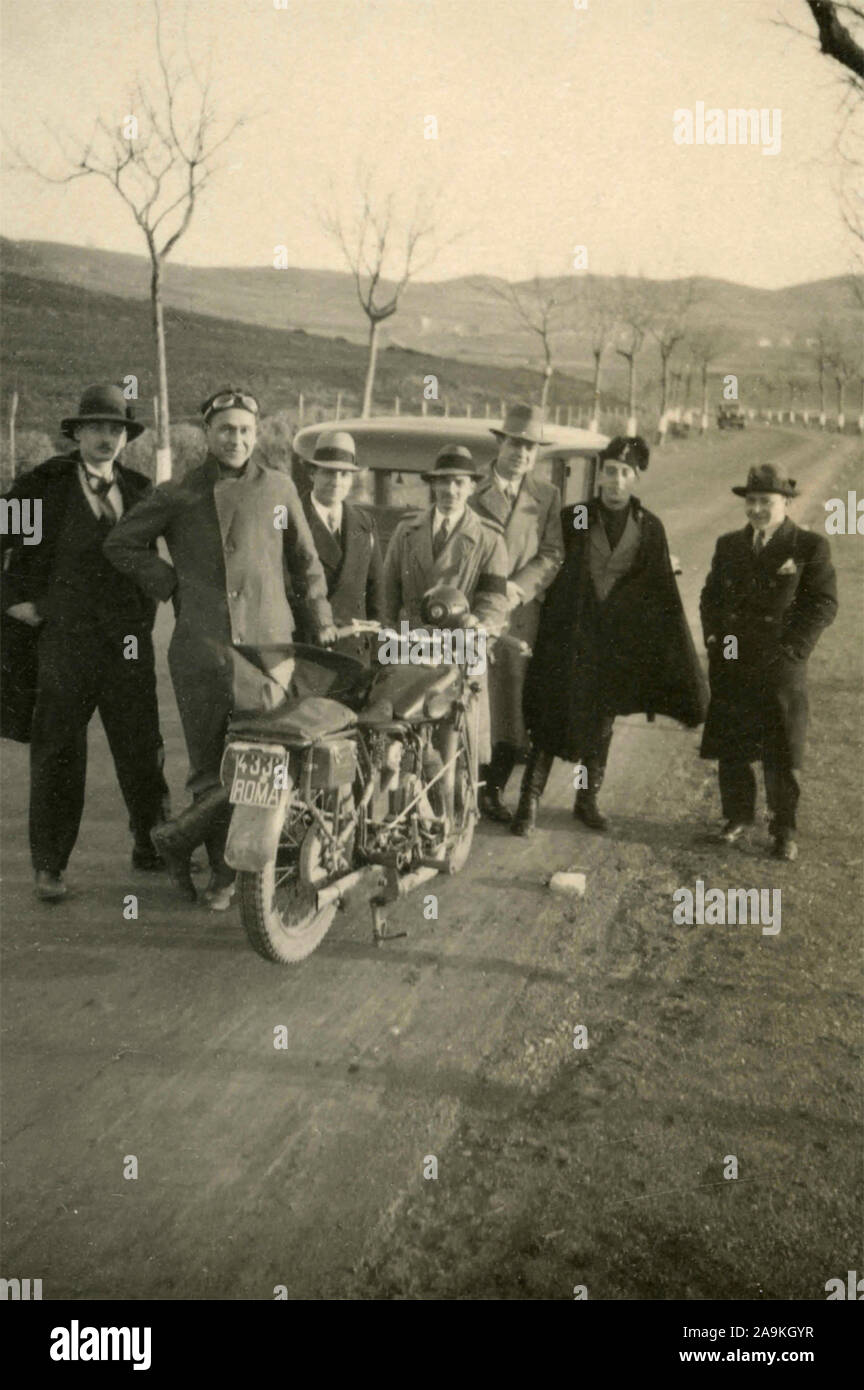 A group of men in the street next to a motorcycle, Italy Stock Photo ...