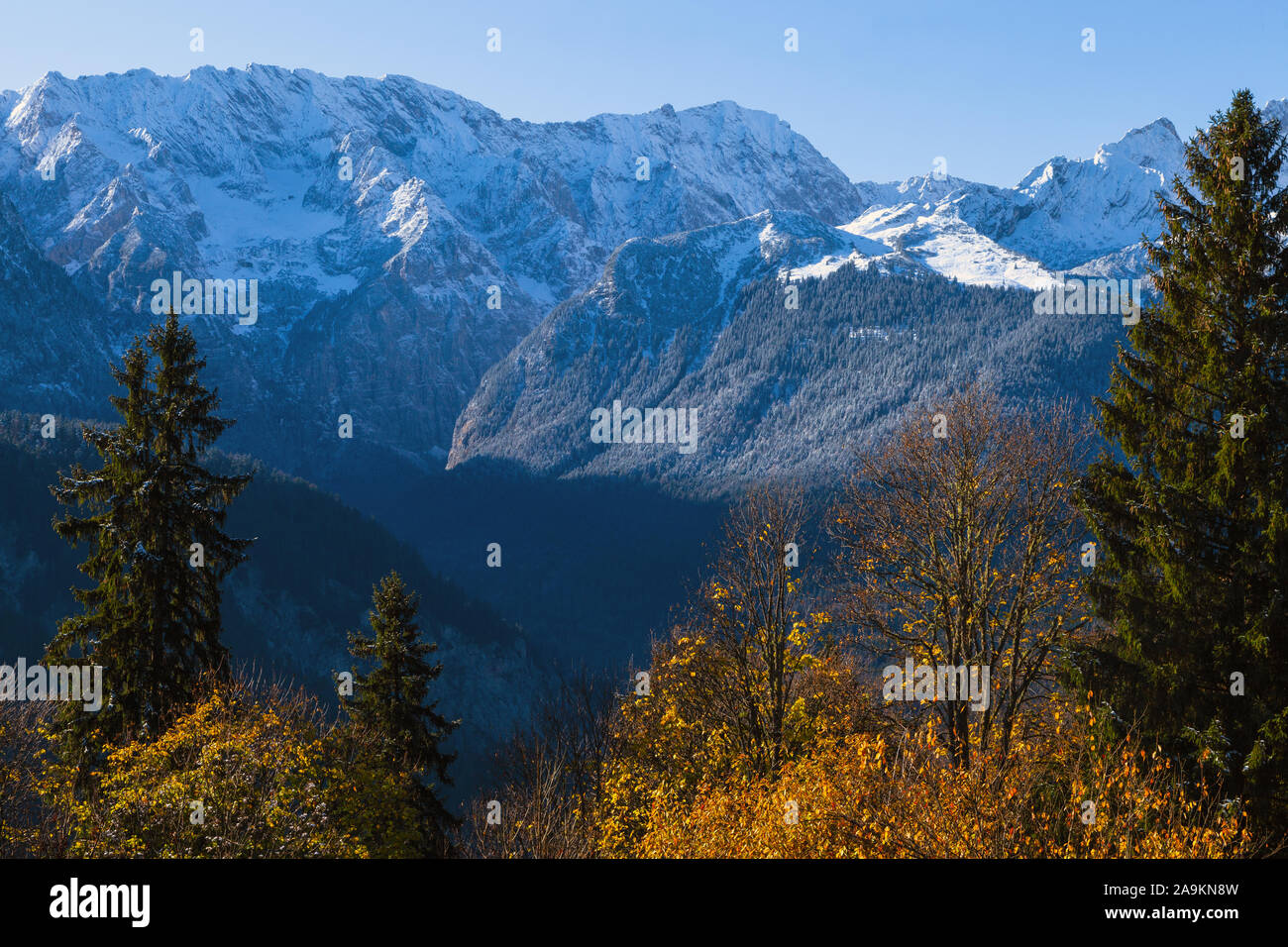 Alpine landscape with coloured trees and white snowy mountains in the ...