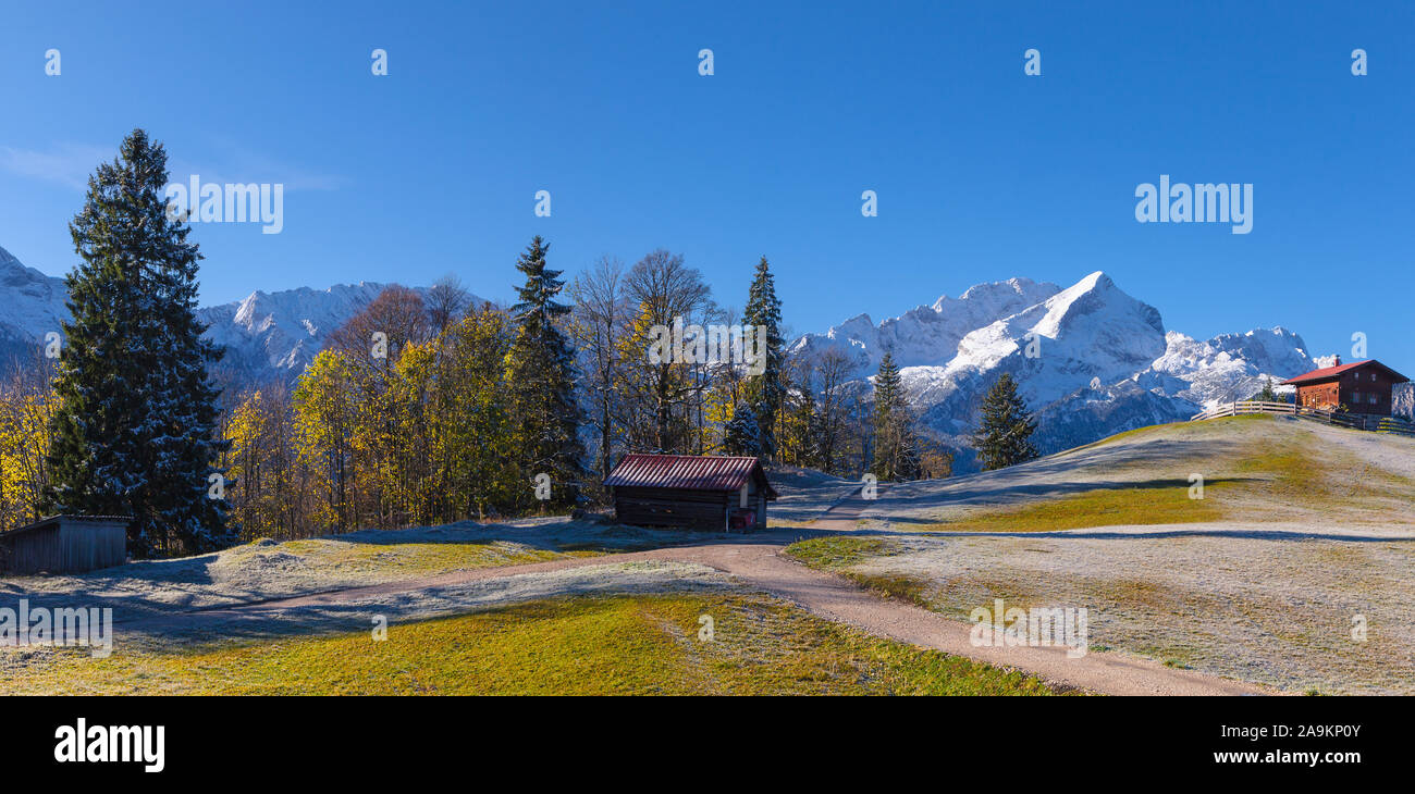 Alpine landscape with coloured trees and white snowy mountains in the ...