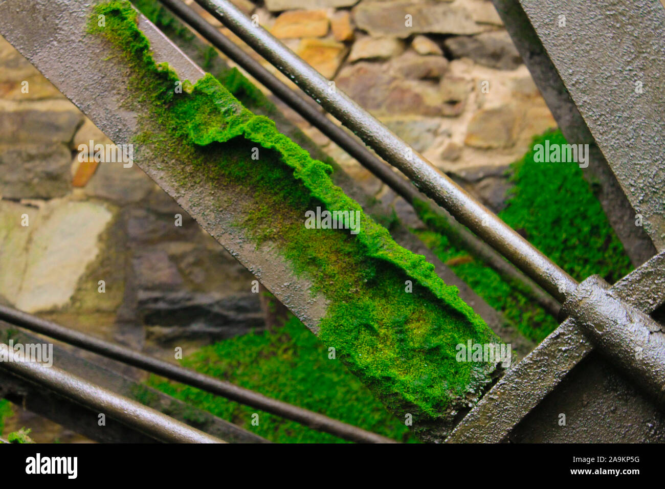 Green Moss on Metal Waterwheel with Stone Wall in Background Stock ...