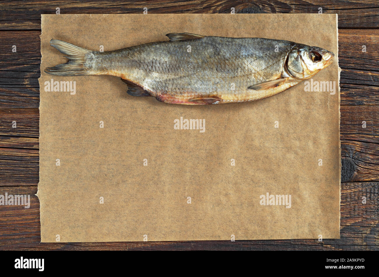 Dried salted fish for beer on paper background on table. Space for text ...