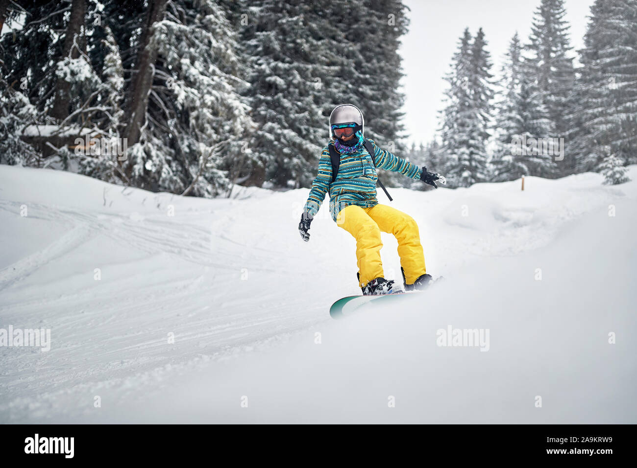 snowboarder snowboarding in snowy mountain.ski resort at mountain Stock ...