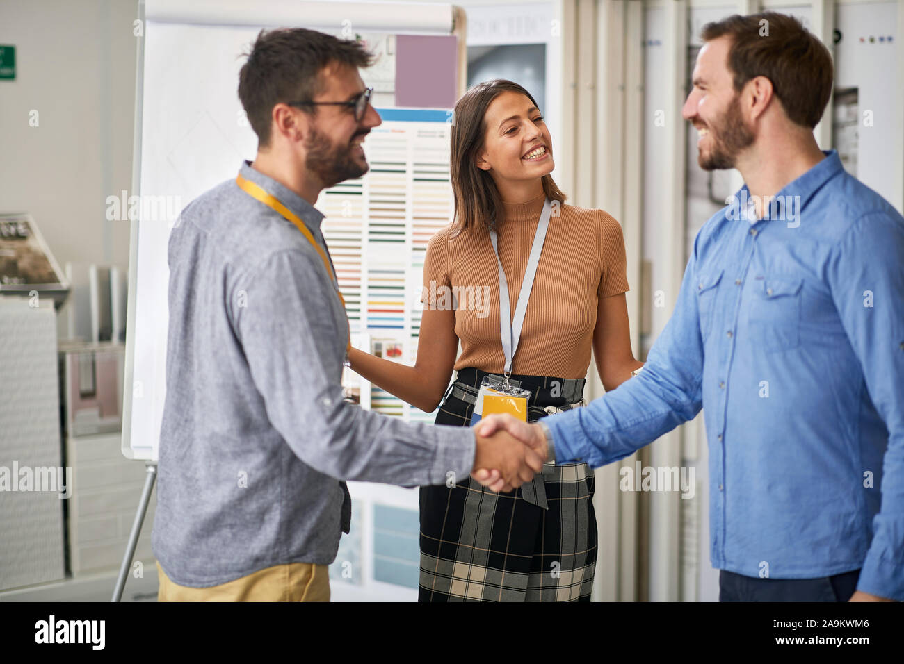 Young happy customer with salesman in store for household Stock Photo ...