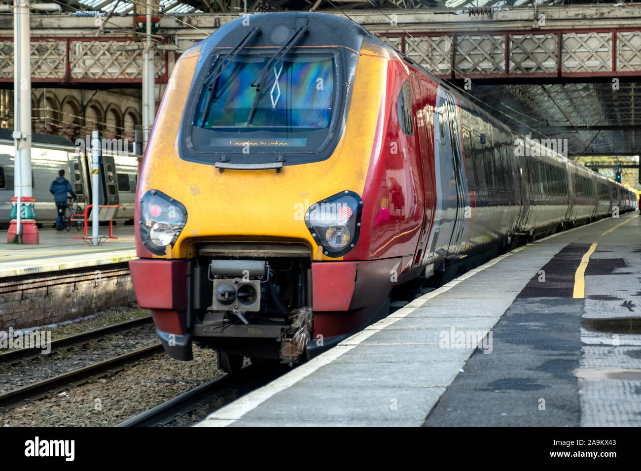 A modern high-speed train at the platform of a vintage-styled train ...