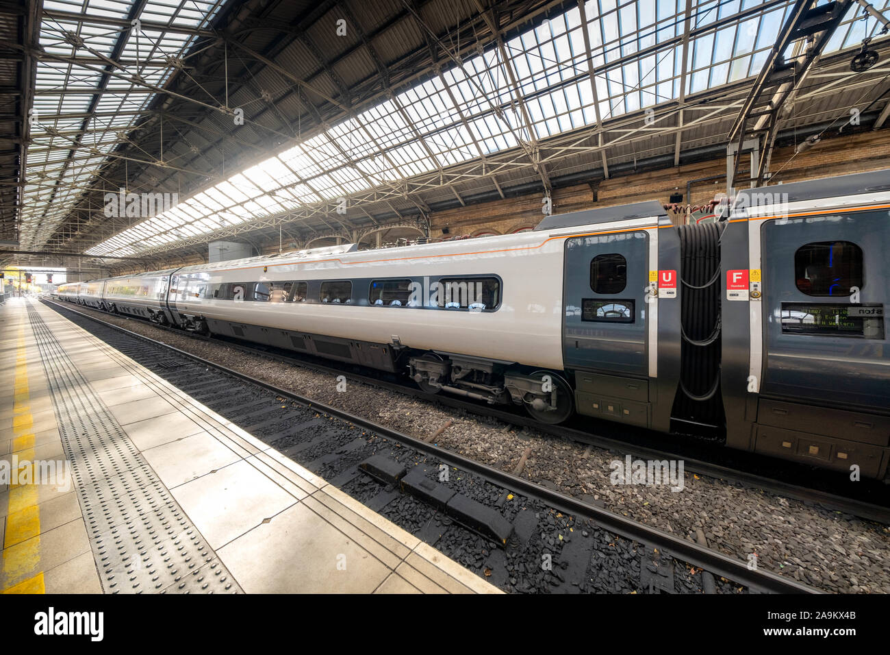 Modern passenger train, stationary at the platform of a covered train ...