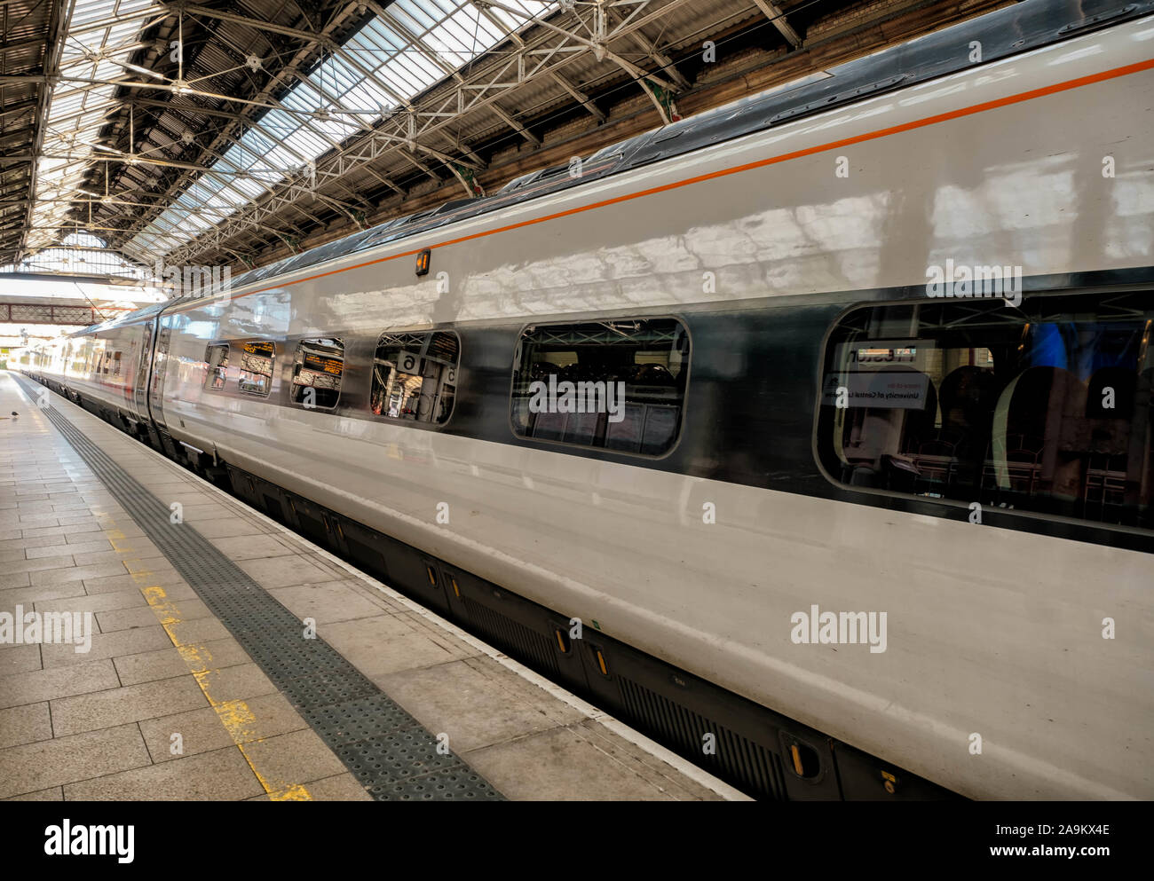 Modern passenger train at station platform awaiting departure with ...