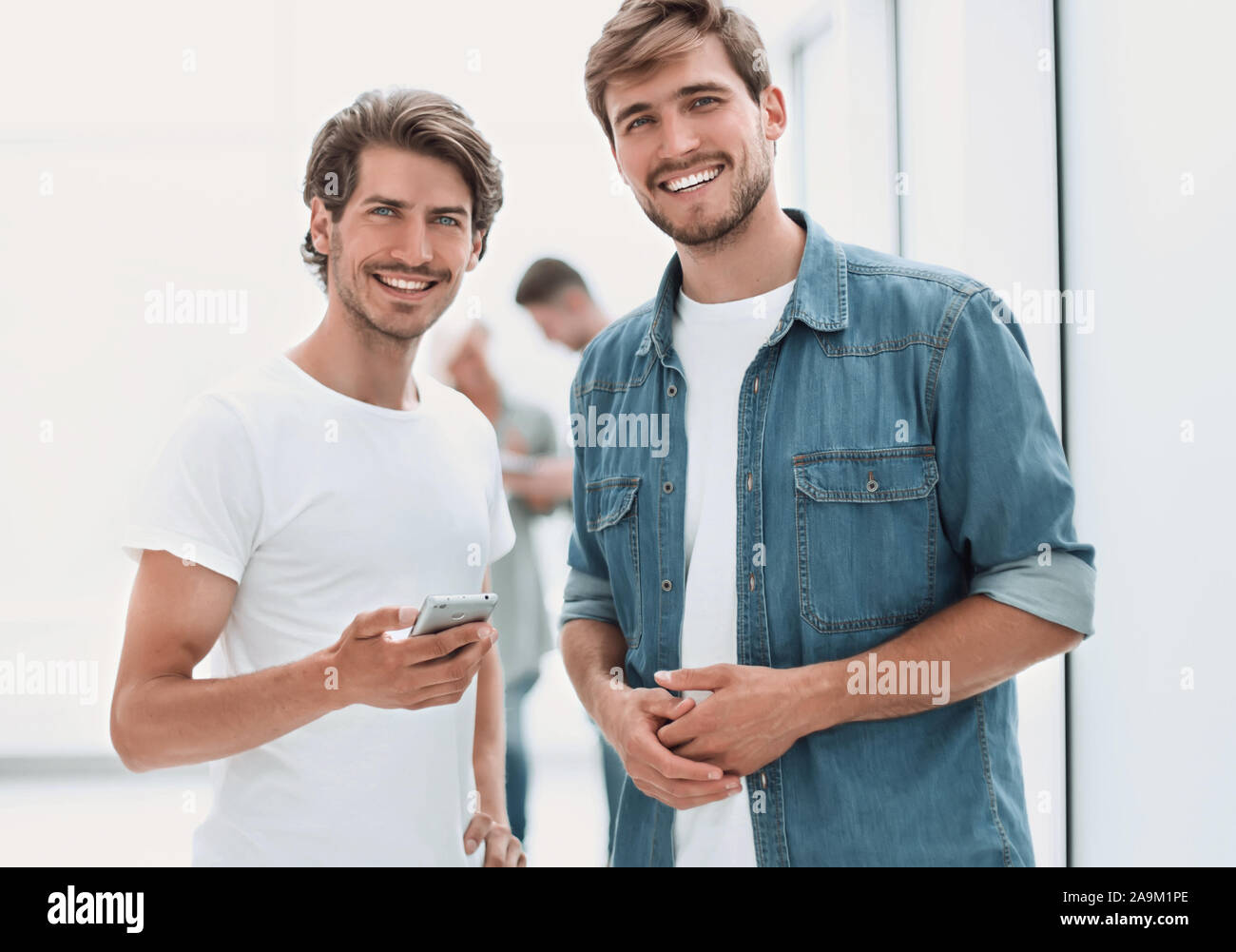 two coworkers standing in the office hallway Stock Photo - Alamy