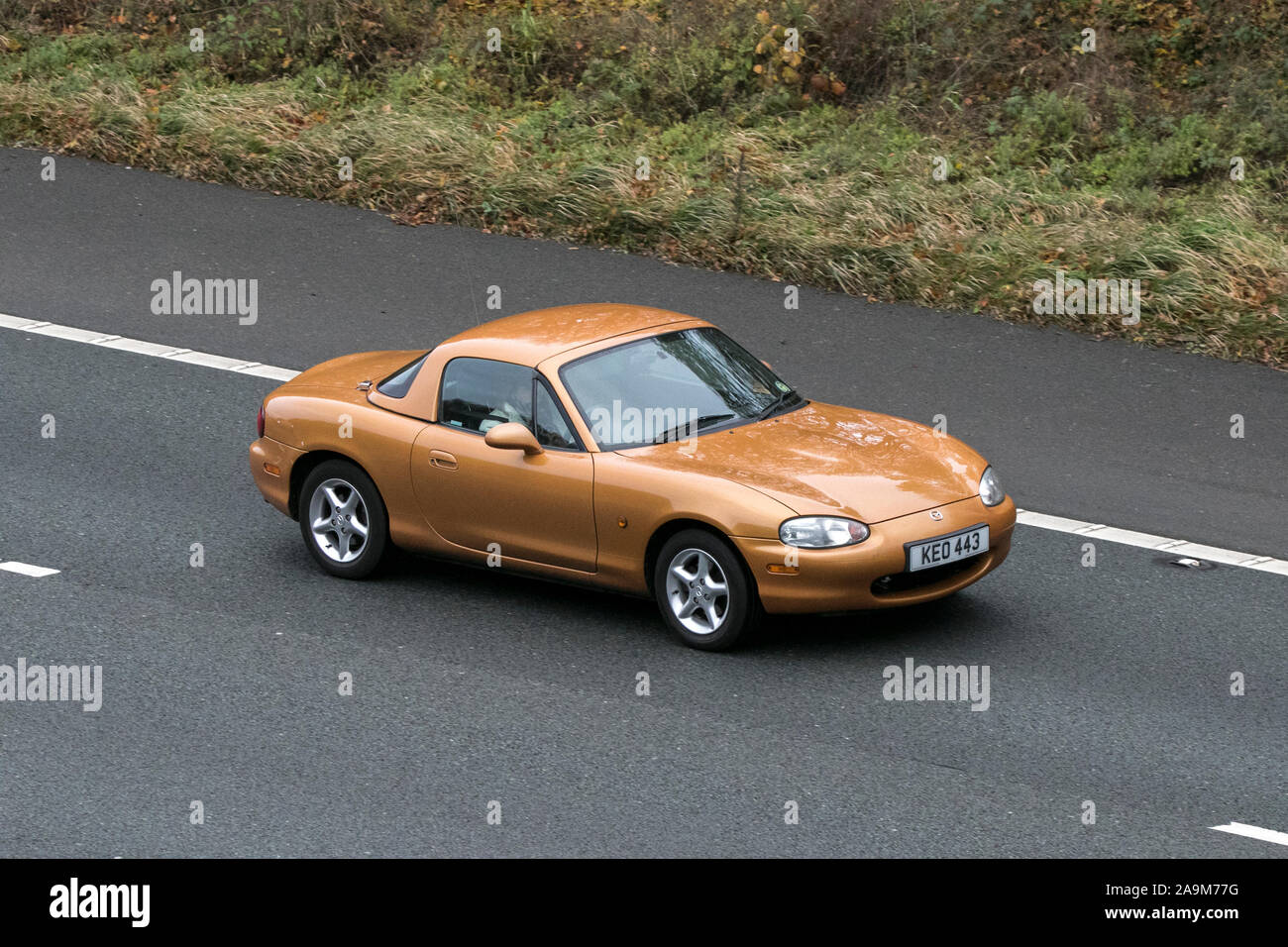 1999 gold Mazda MX-5 Miata travelling on the M6 motorway, Lancaster, UK ...