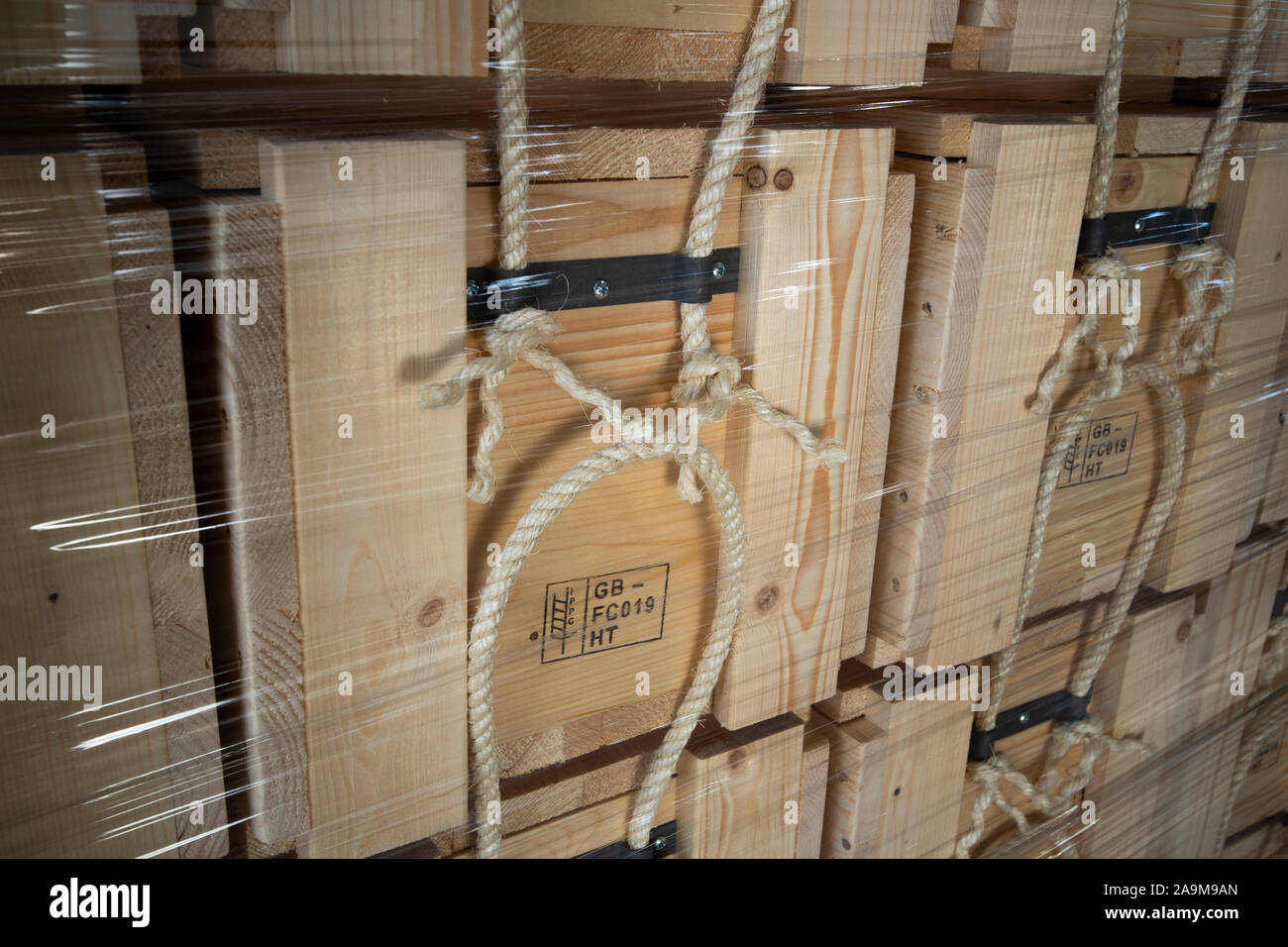 Stacked timber packing boxes with rope carrying handles wrapped in ...