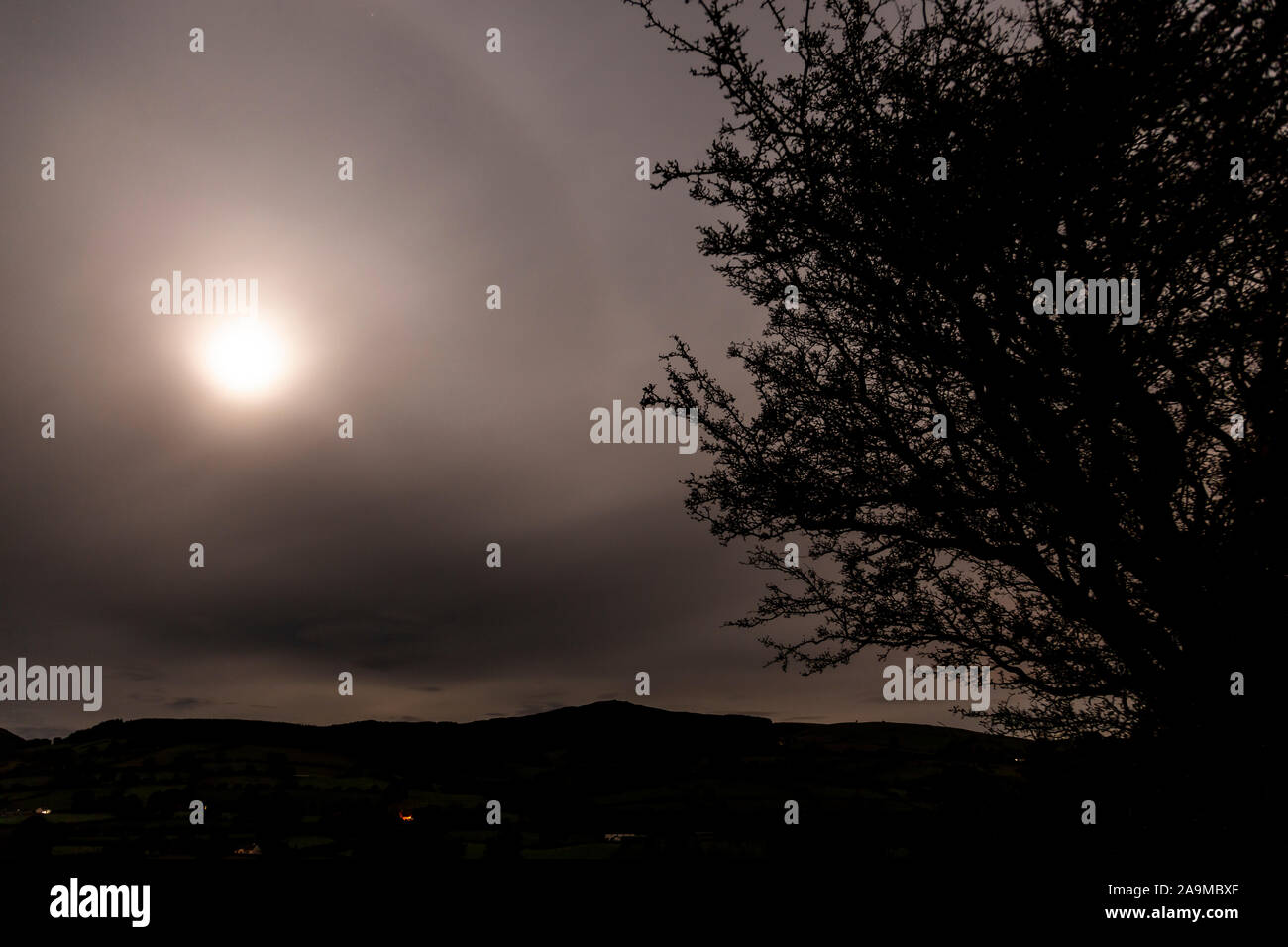 Full moon shining through clouds over the Clwydian Range AONB, North ...