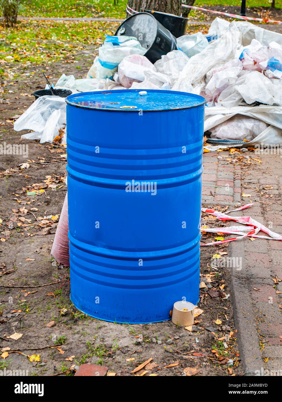 Blue metal barrel on a background of construction debris. Place for ...