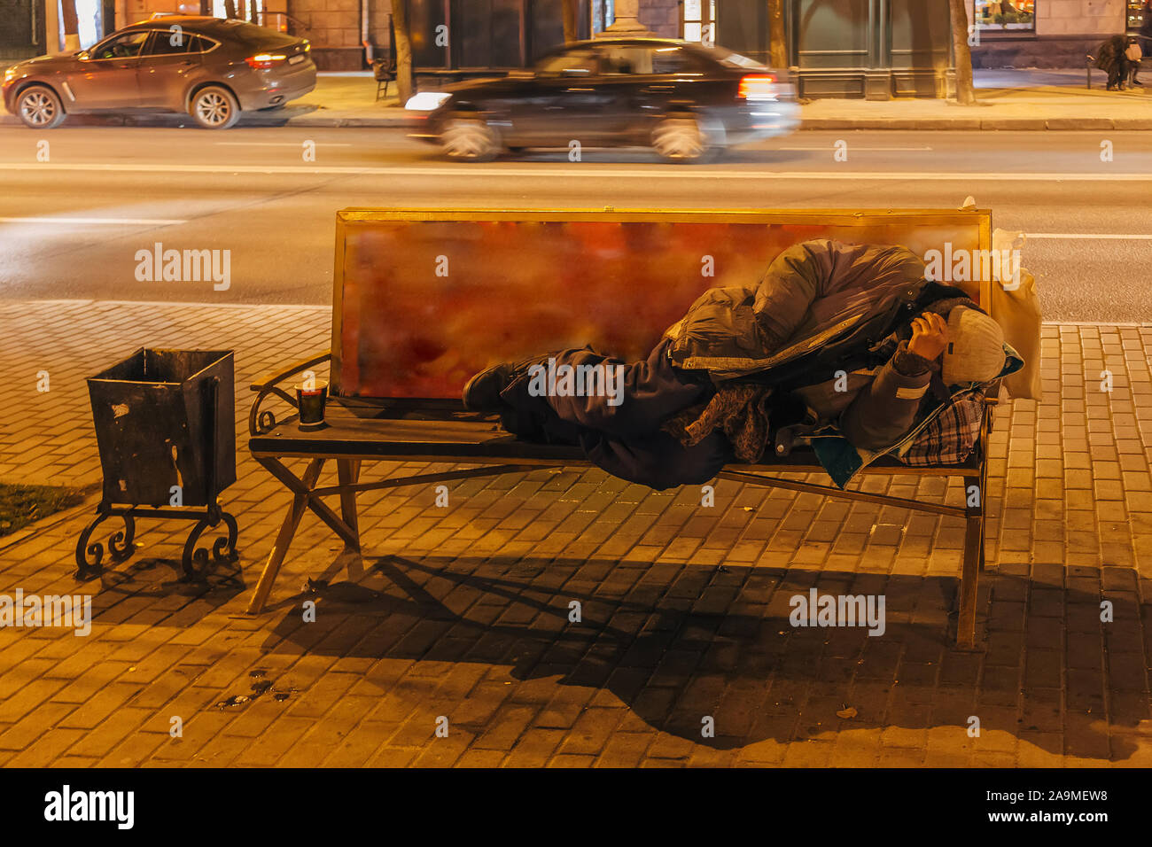 Unknown homeless or alcoholic or drug addict are sleeping on the bench ...