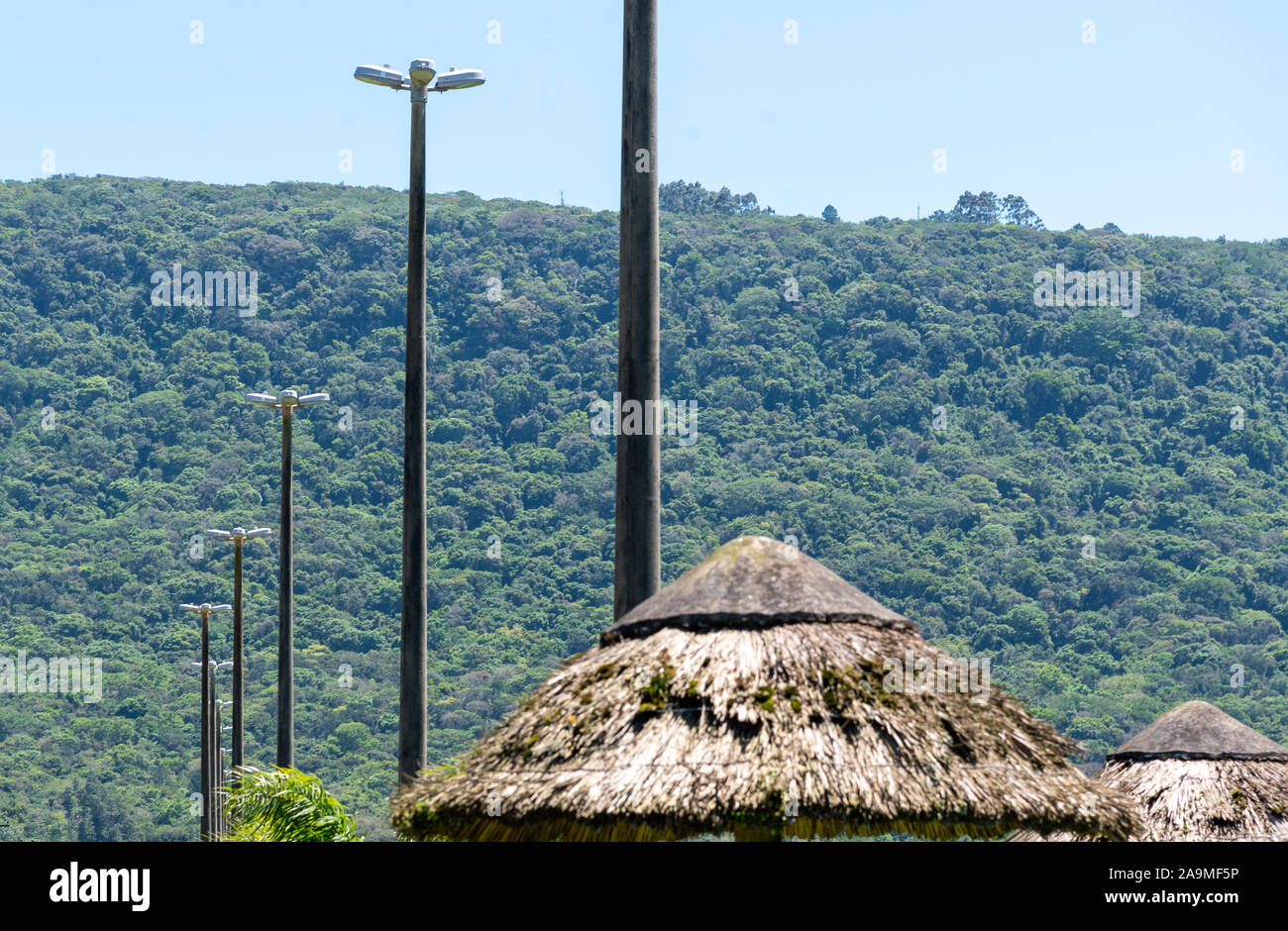 View of a kiosk thatched roof and profiled public streetlights in ...