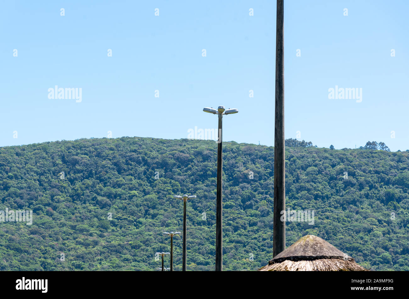 View of a kiosk thatched roof and profiled public streetlights in ...