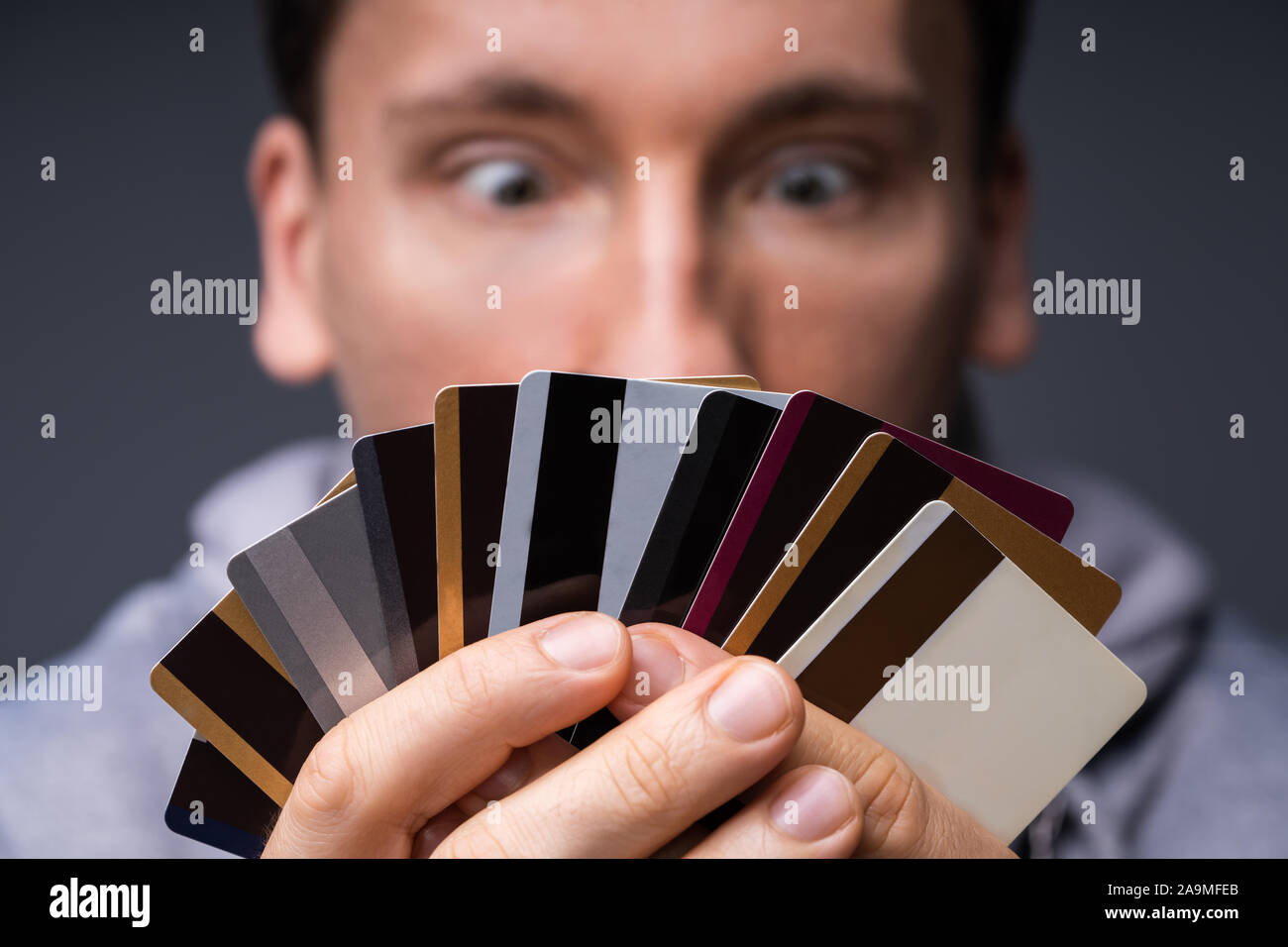 Shocked Man Looking At Too Many Credit Cards Holding In His Hand Stock ...