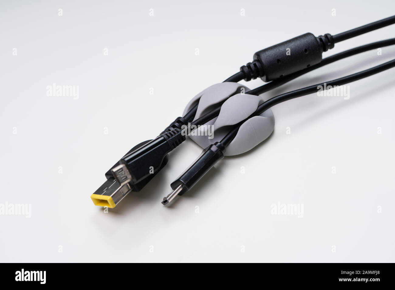 Overhead View Of Sticky Cable Holder On White Desk With Charging Cables ...