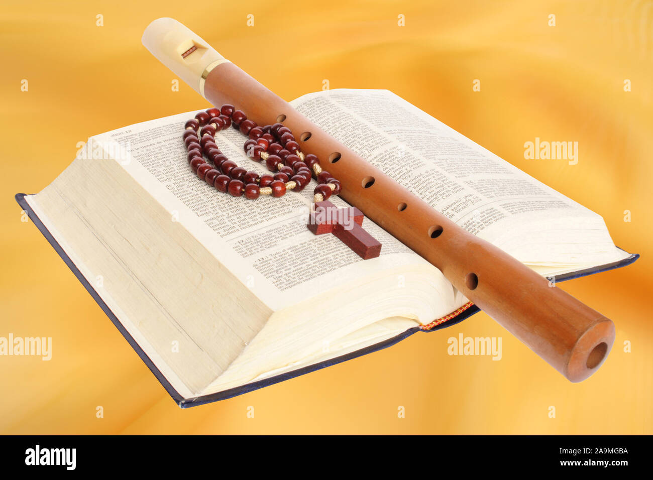 Open bible and rosary with a flute on a yellow background Stock Photo ...
