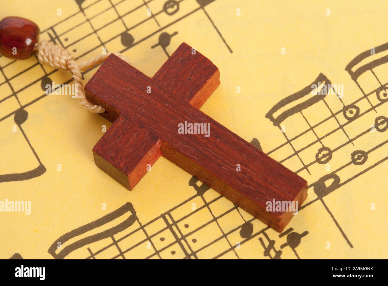 Small wooden cross over a yellow sheet of religious music Stock Photo ...
