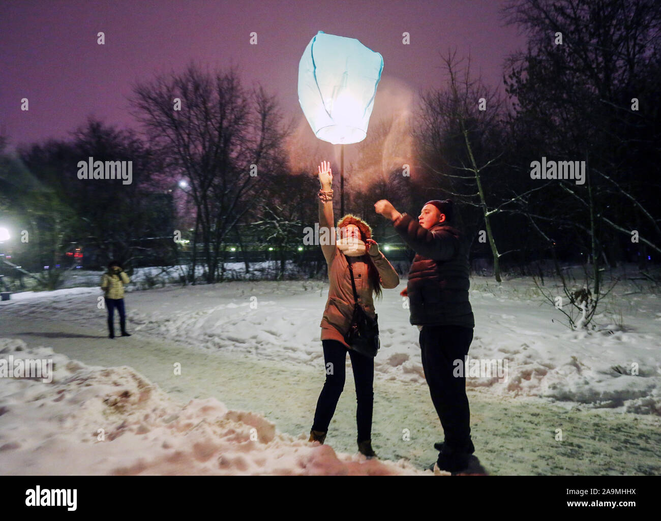 young couple launches a flashlight in the sky. January 1 evening on the ...