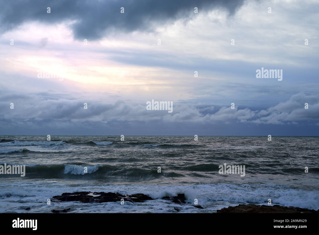 Next view of the churning sea in the evening with dark menacing clouds ...
