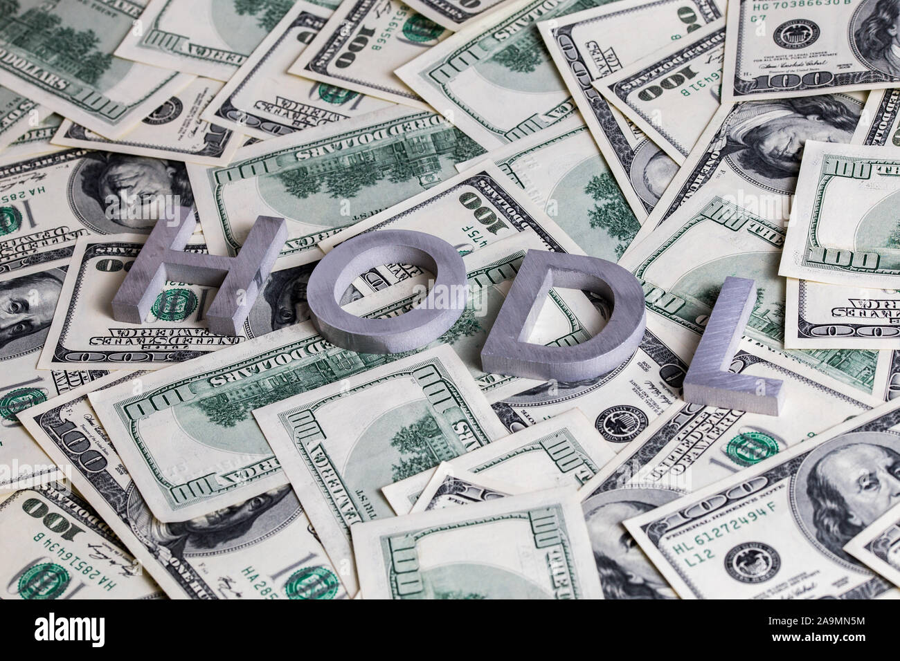 The words HODL laid with aluminium letters on the US dollar banknotes ...
