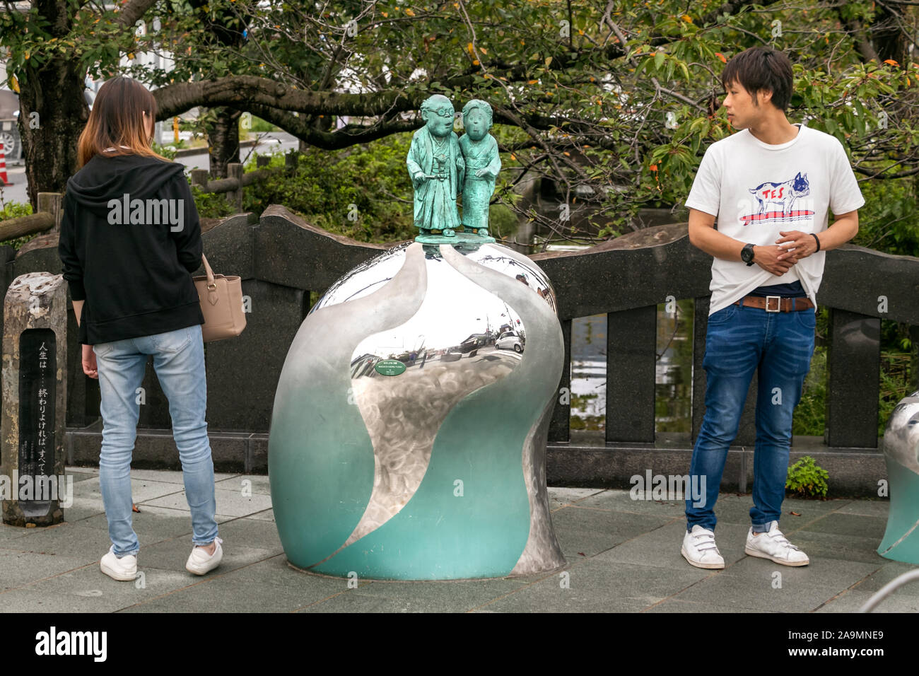 Japanese couple looking Shigeru Mizuki statues at Mizuki Shigeru Road ...
