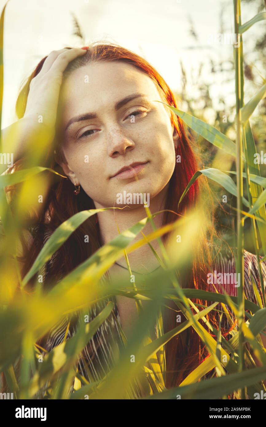 happy red hair young woman in reed looking back at camera, smiling ...