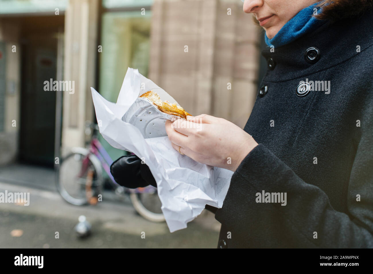 Side view of woman eating looking at the traditional Alsatian tarte ...