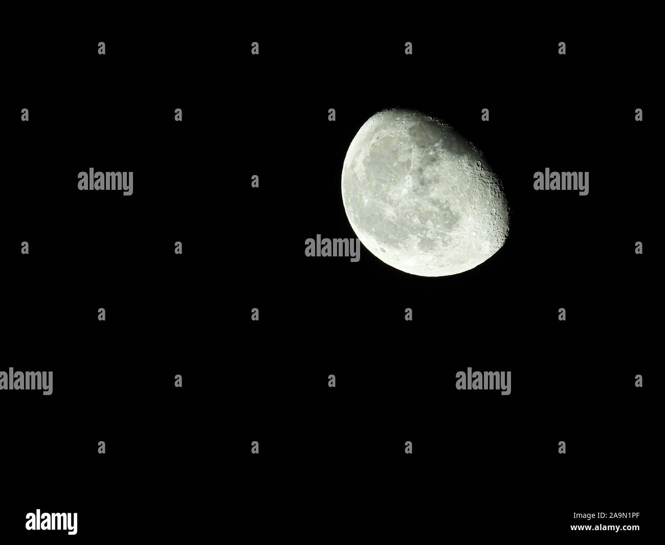 a close-up of the waning three-quarter moon in the starry night sky ...