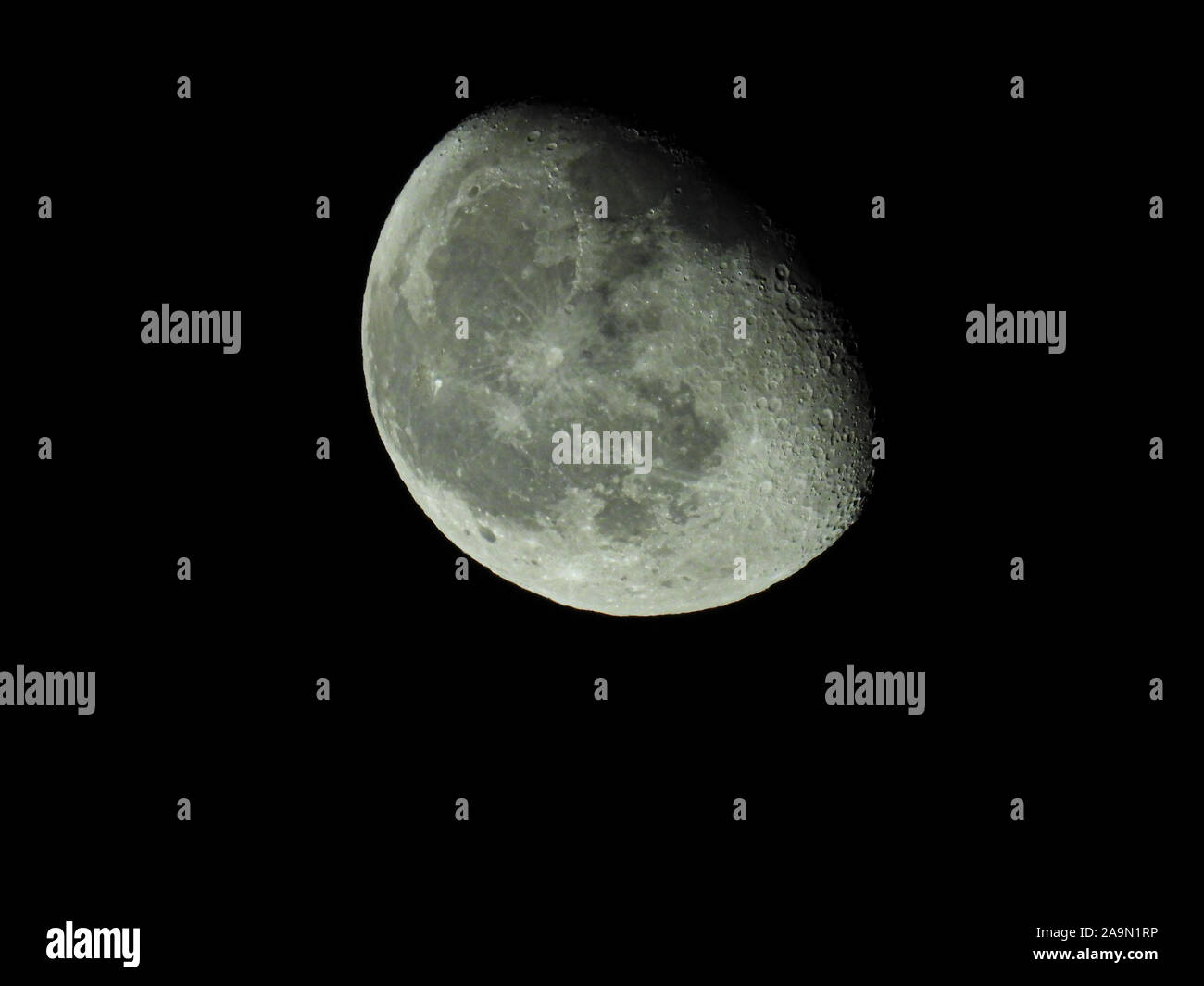 a close-up of the waning three-quarter moon in the starry night sky ...