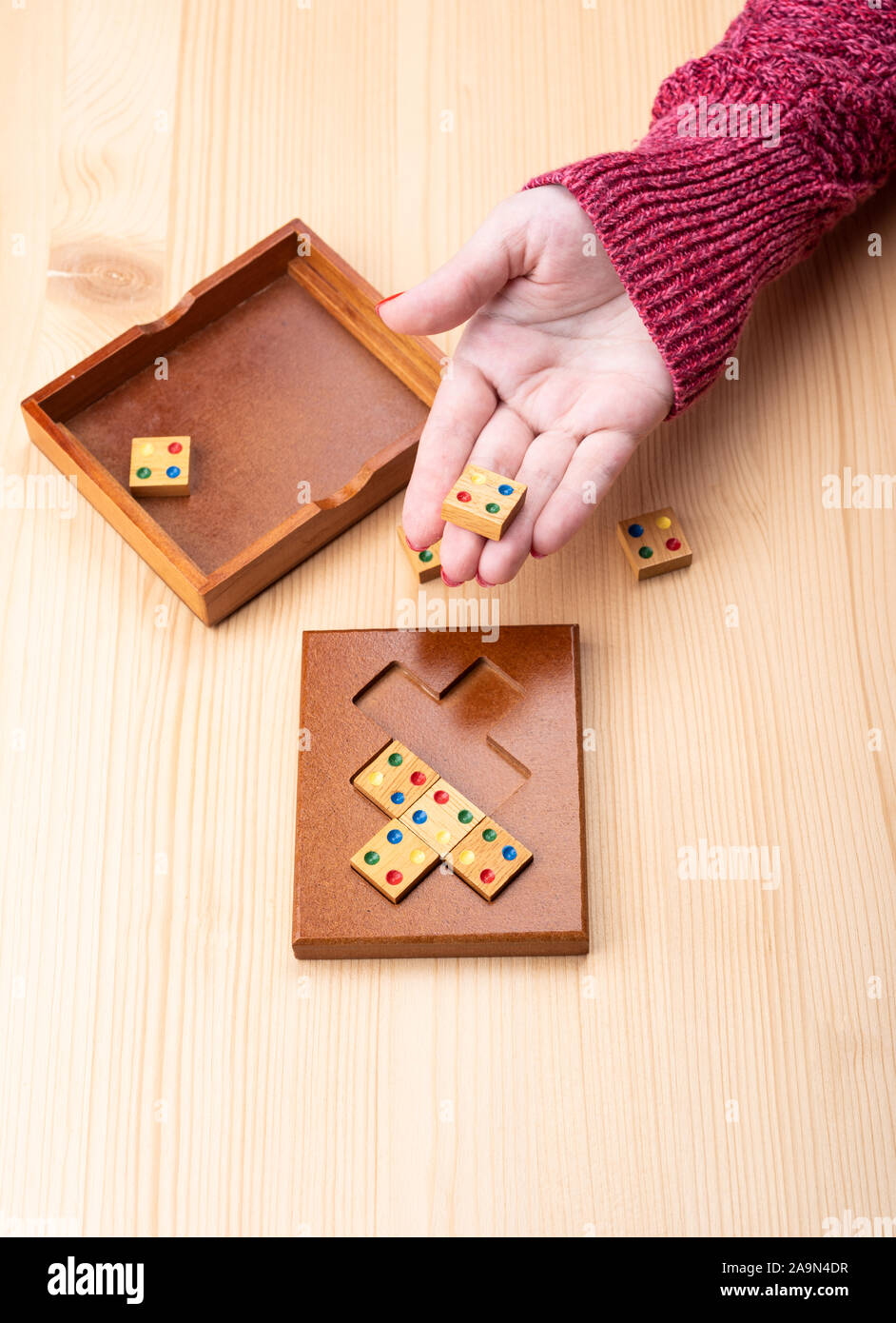 Girl is trying to assemble a mosaic puzzle. Bright manicure on ...