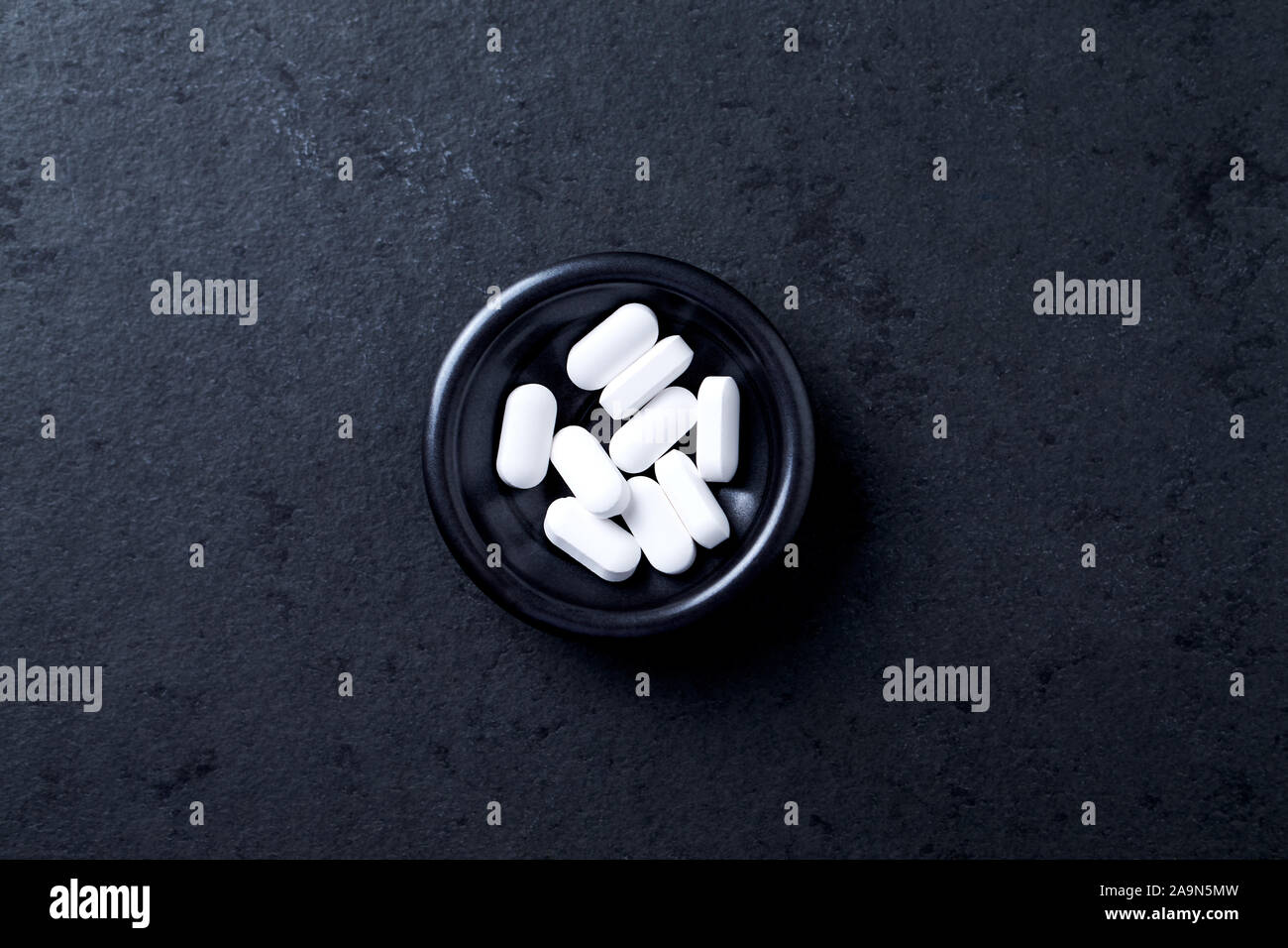 Magnesium tablets on dark stone background. Top view. Copy space Stock ...