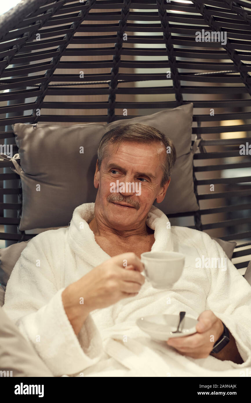 Portrait of wealthy senior man relaxing in lounge chair at luxury SPA ...