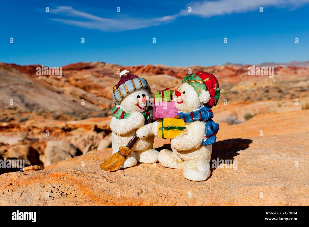 Snowman Figurines in dry desert setting with mountains in the ...