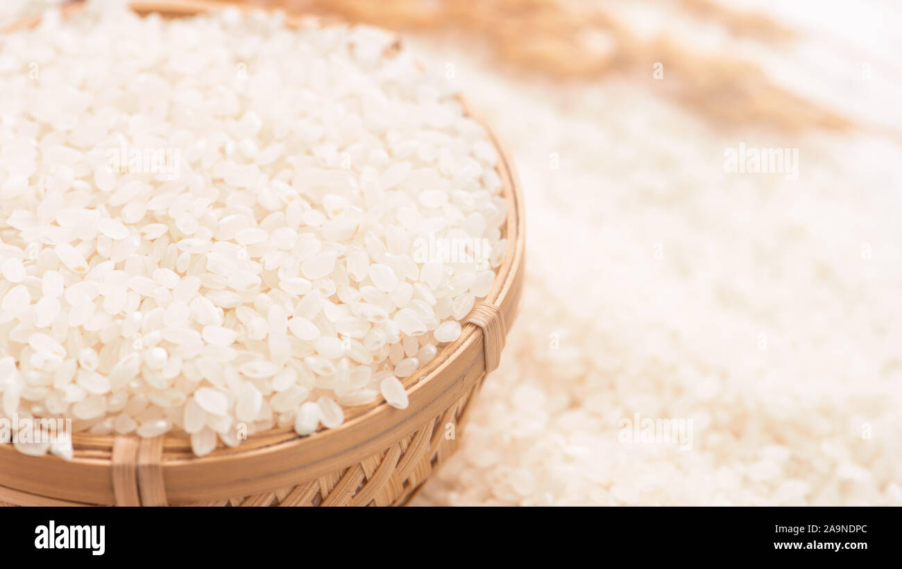 Raw white polished milled edible rice crop on white background in brown ...