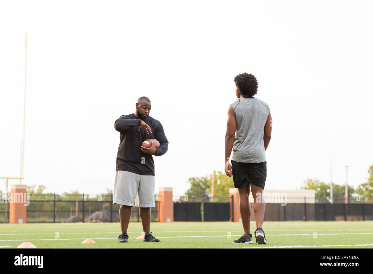 American Football coach training a young athlete Stock Photo - Alamy