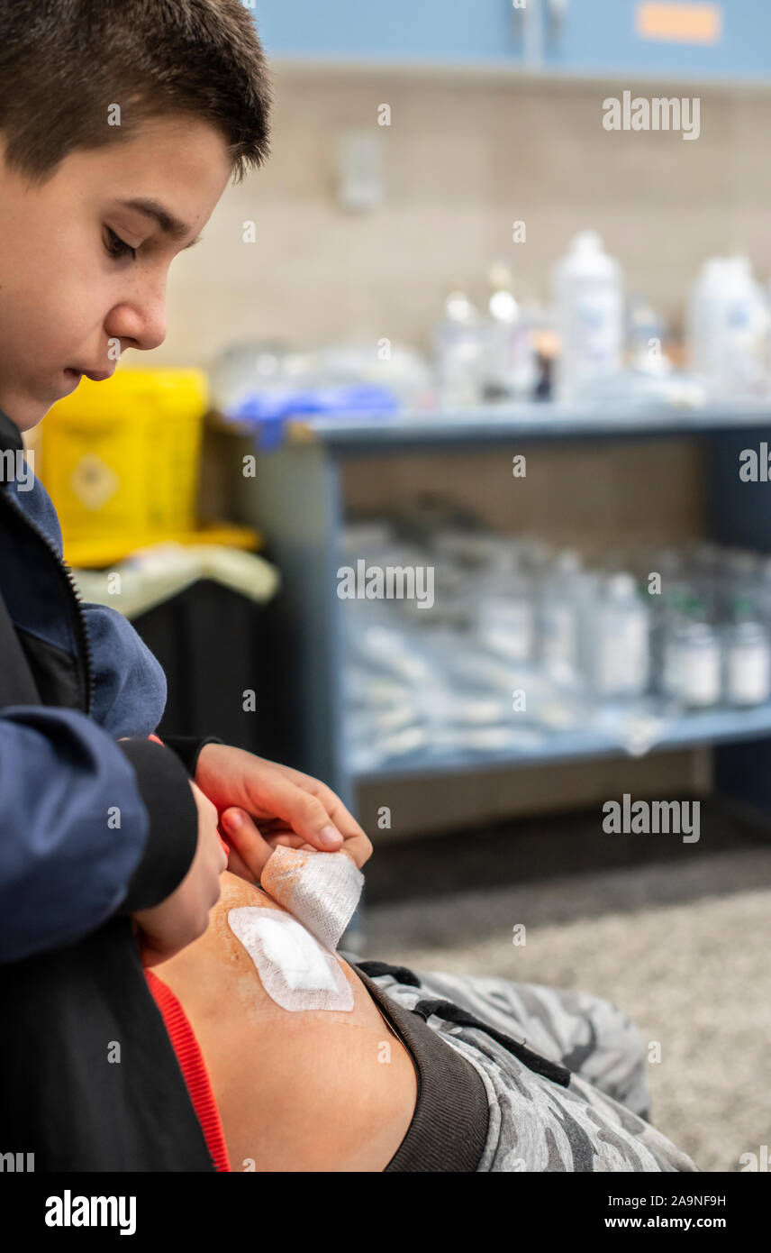 Young teenage boy in hospital. Child with cut wound in medical cabinet ...